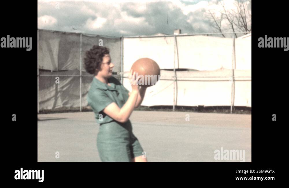 1950s: Basketball court. Women catch and throw passes. Woman guards ...