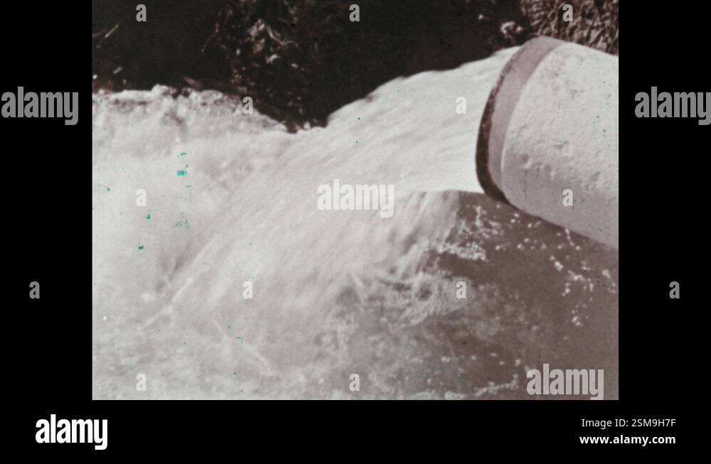 1960s: Water pours from pipe into ditch. Woman fills coffee pot with ...