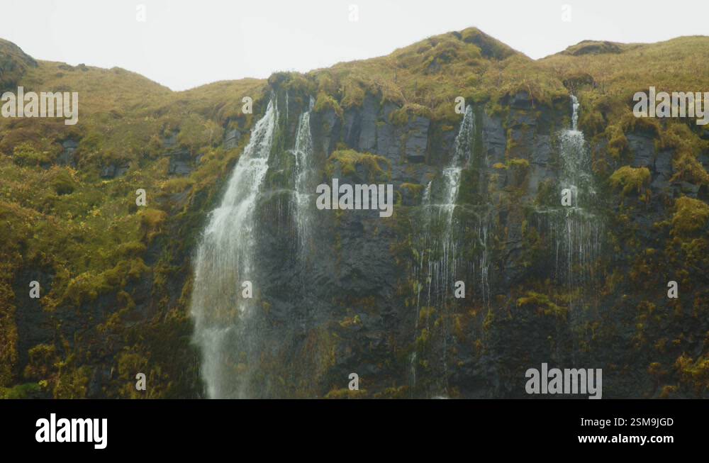 Stunning view of small streams of a waterfall running of a tall cliff ...