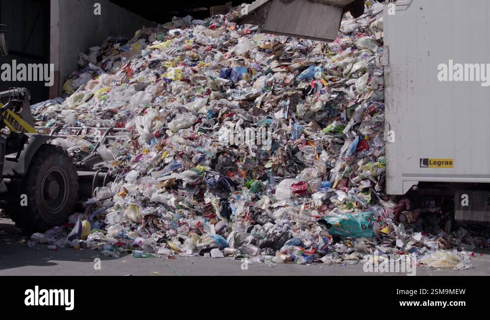 In a recycling center, a waste truck unloading, process of managing and ...