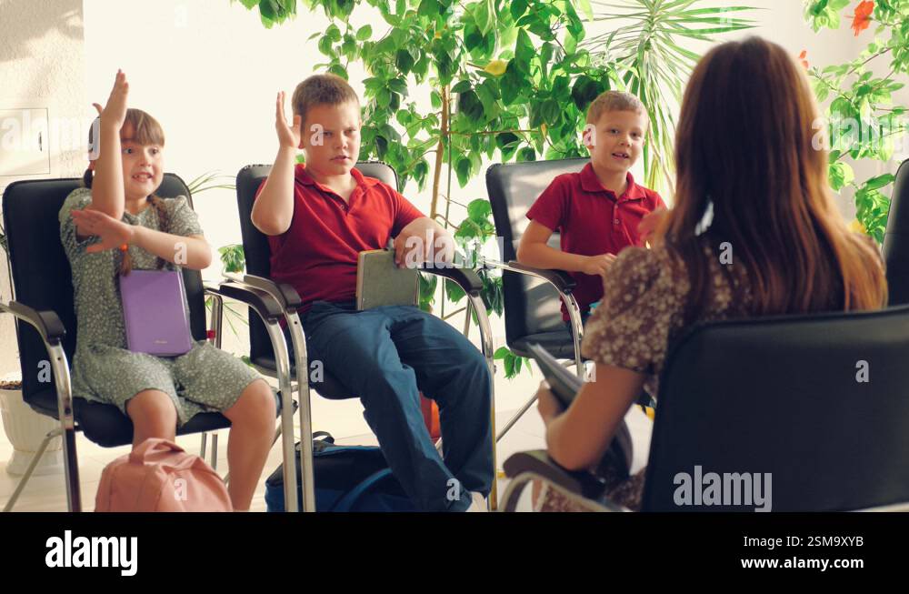 Involved little children answer teacher questions resting in extended ...