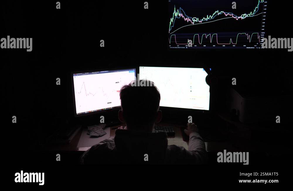 Financial analyst working at night analysing real-time stocks and ...