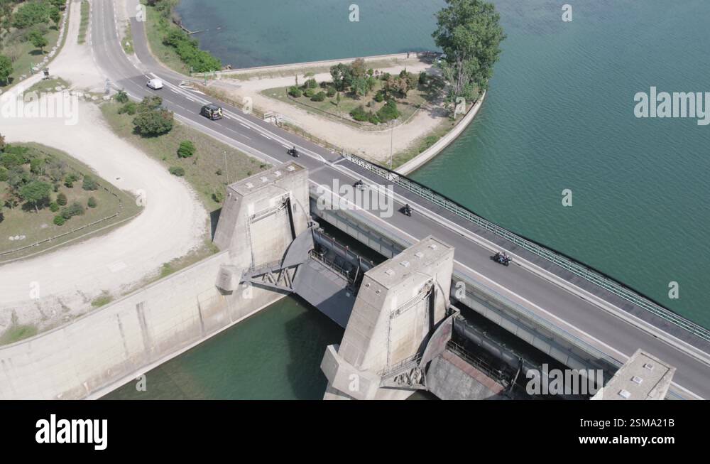 Motorcycle Biker Group on the Road Cross A Dam Over a River - Aerial ...