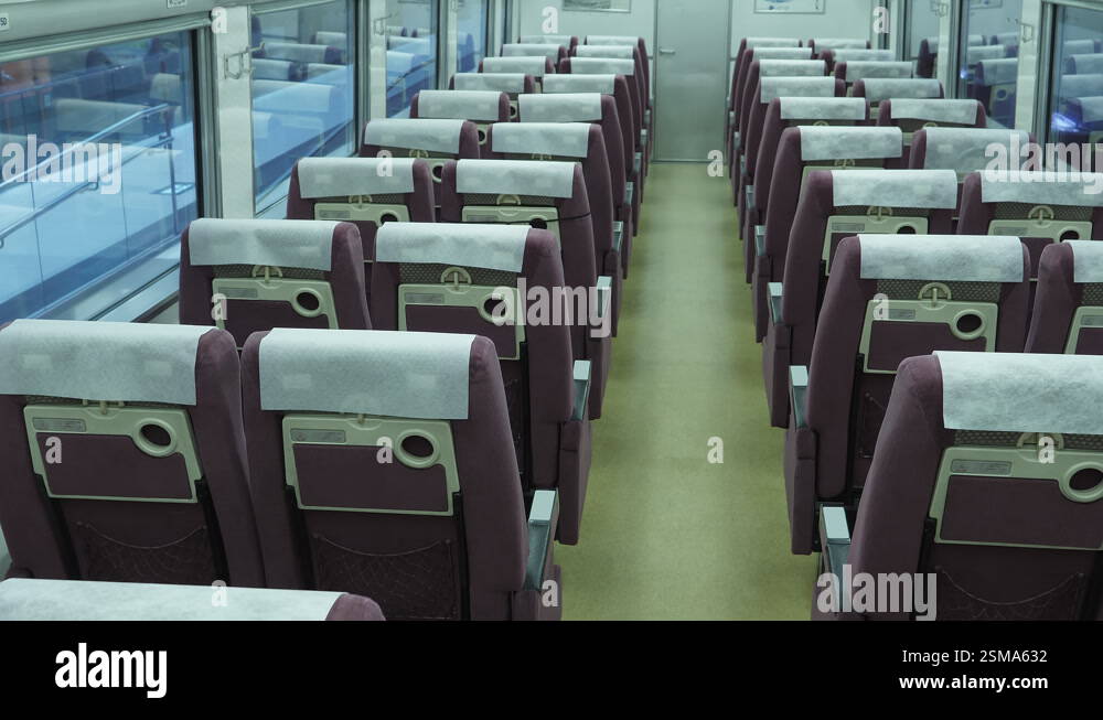 Rows of purplish seats inside a train wagon. Camera slowly tilting ...