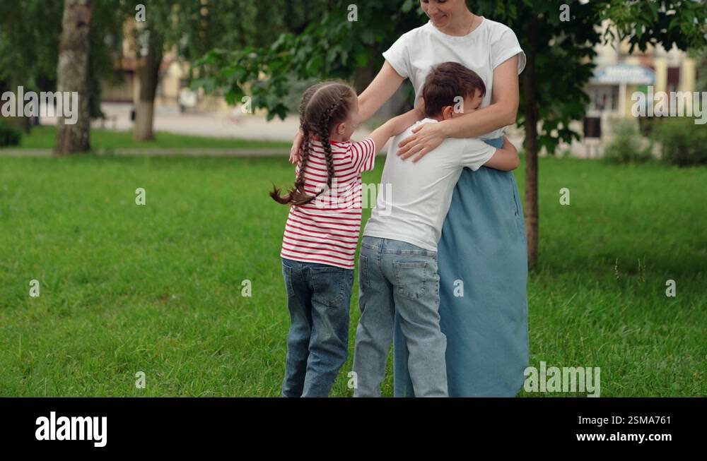 Happy children, boy, girl run to mother, hug her. Mom hugs child, son ...