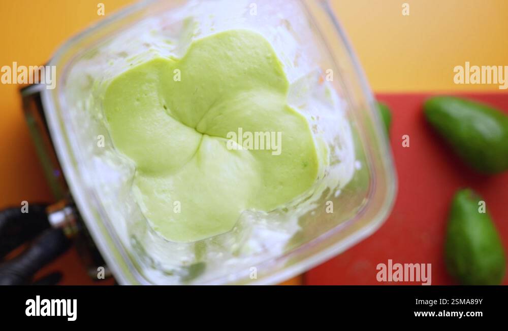 Prepare an avocado smoothie in a blender. Angle from above. slow motion ...