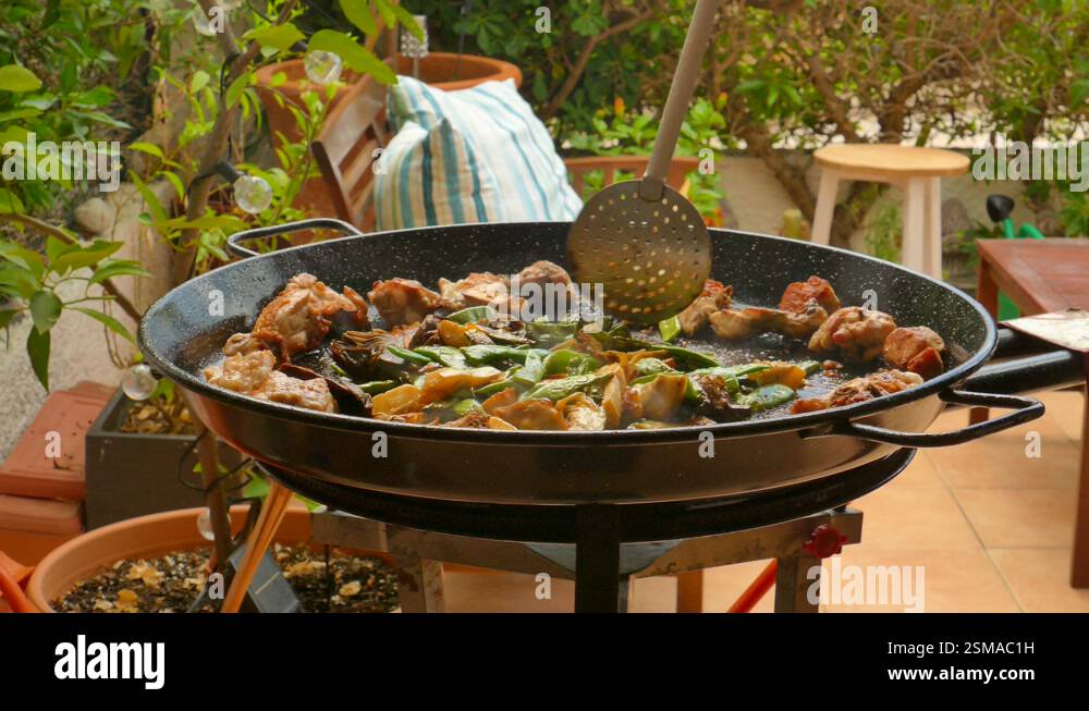 Pan shot during Traditional paella preparation, from the Valencian ...