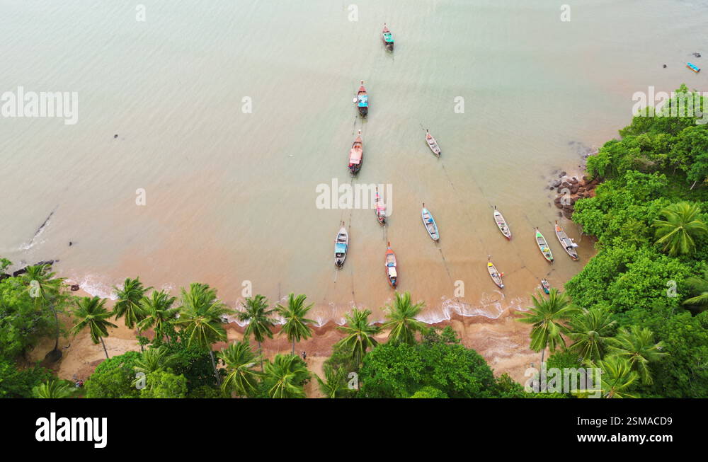 Passenger boats tied up together at the coast of Koh Lanta surrounded ...