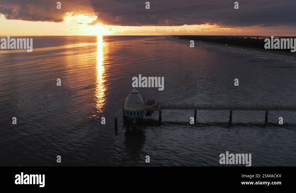 Surounding shot of a Diving bell at the end of a pier at sunrise golden ...