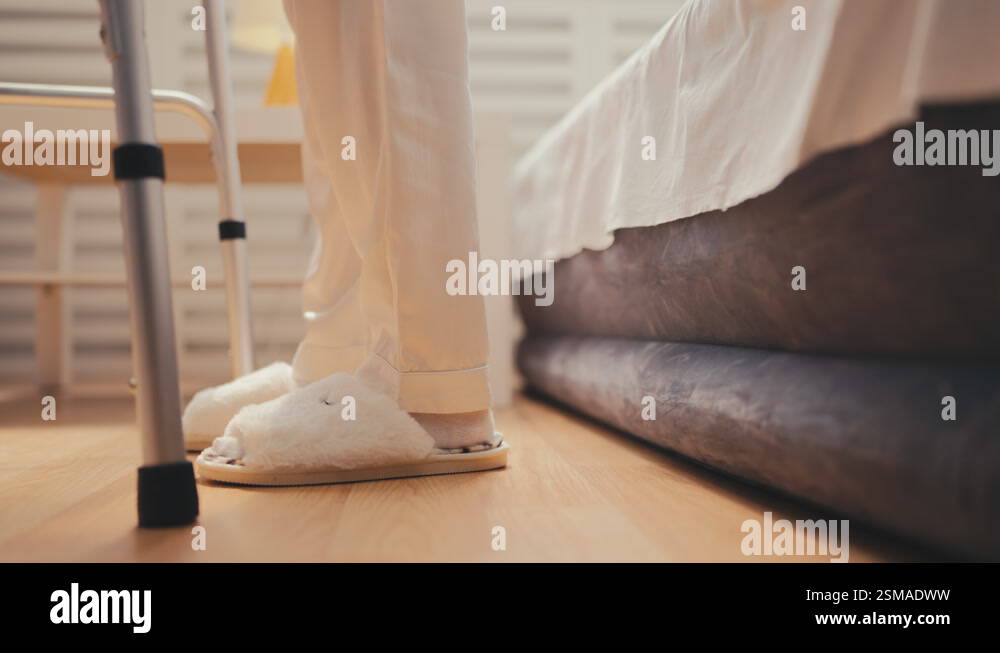 Feet of old woman moving with a walking frame in bedroom, senior age ...