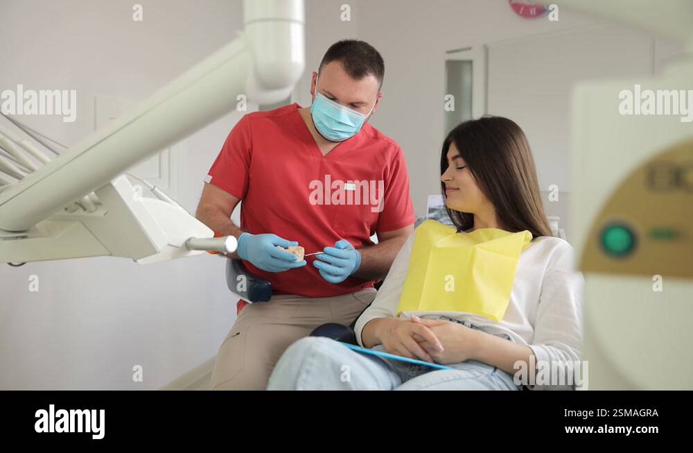 A dentist shows an orthodontic plastic jaw bite to a patient. Health ...