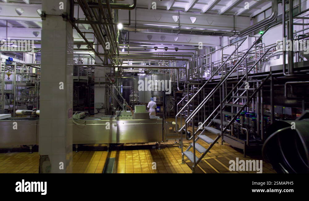 Worker with lab coat walks past metal tanks for chemicals Stock Video ...
