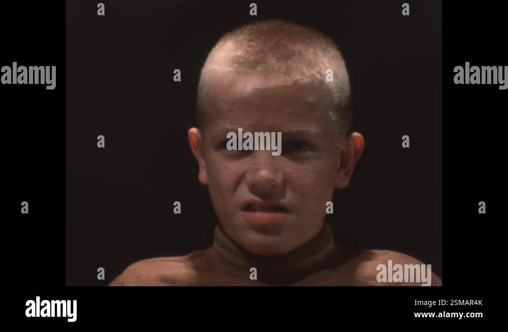 1970s: Boy looks straight ahead , frowns and curls his lip in disgust ...