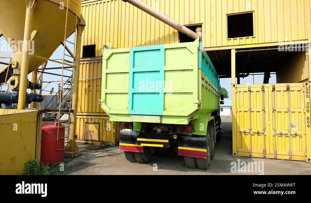 Process of pouring aggregate on a truck. Truck approaches the mixer ...