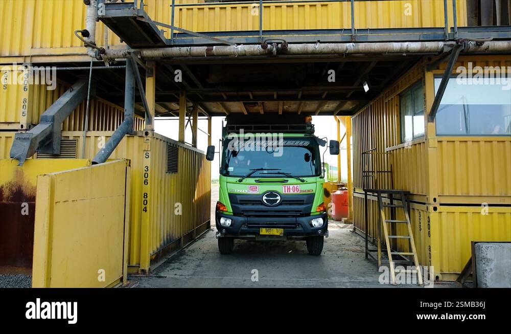 Process of pouring aggregate on a truck. Truck approaches the mixer ...