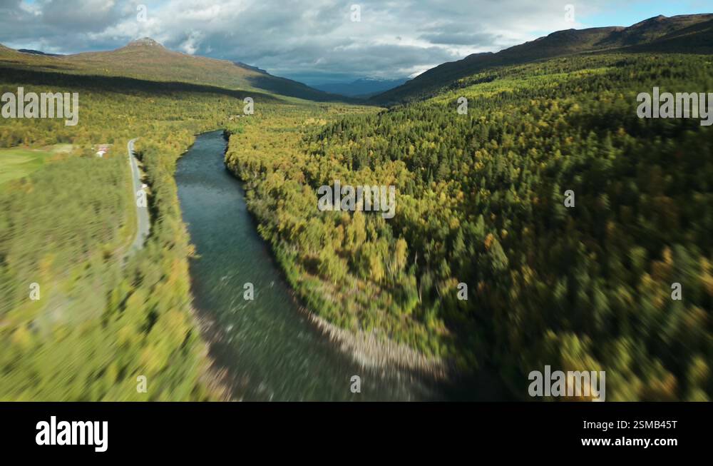 A wide forest-covered valley. A river meanders through the valley ...