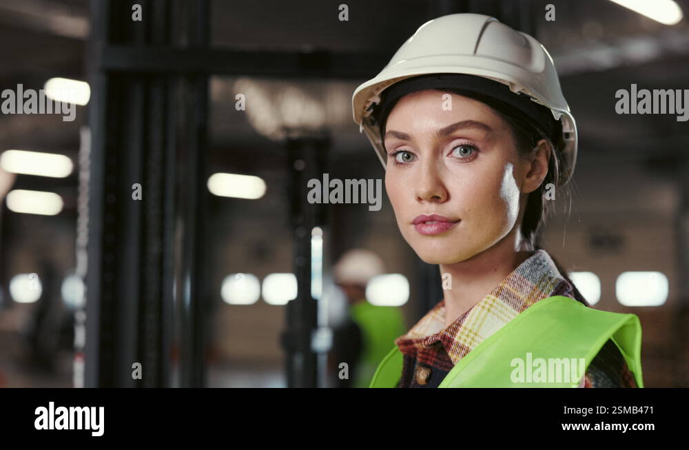 Portrait of a Caucasian female forklift operator, dressed in a green ...