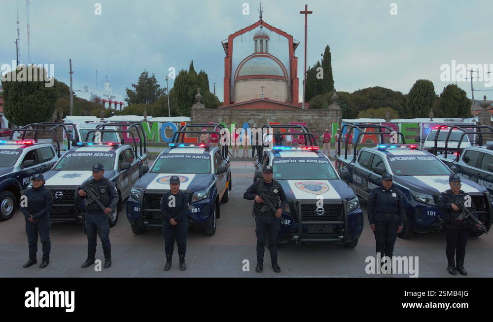 Vertical pan of 7 police pick ups and 2 ambulances with armed officers ...
