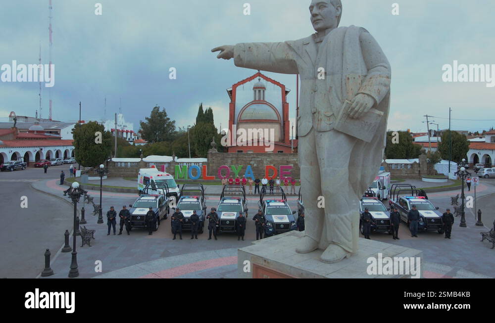 Vertical pan of 7 police pick ups and 2 ambulances with armed officers ...