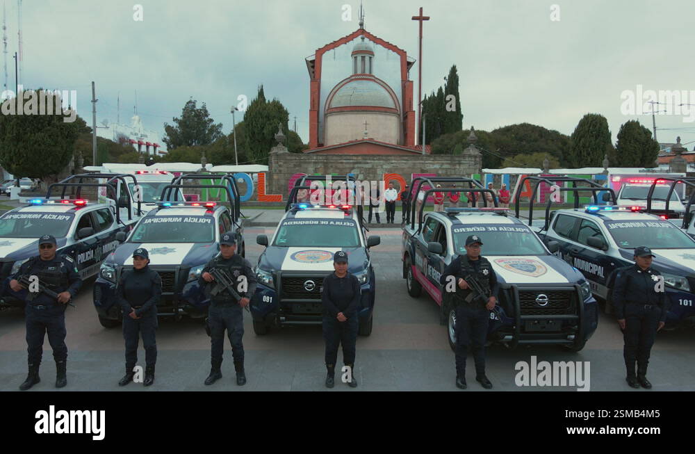Vertical pan of 7 police pick ups and 2 ambulances with armed officers ...
