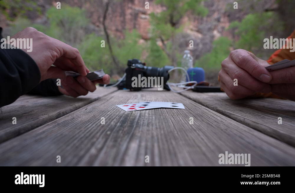 Two young men play a friendly game of speed with a deck of cards on a ...