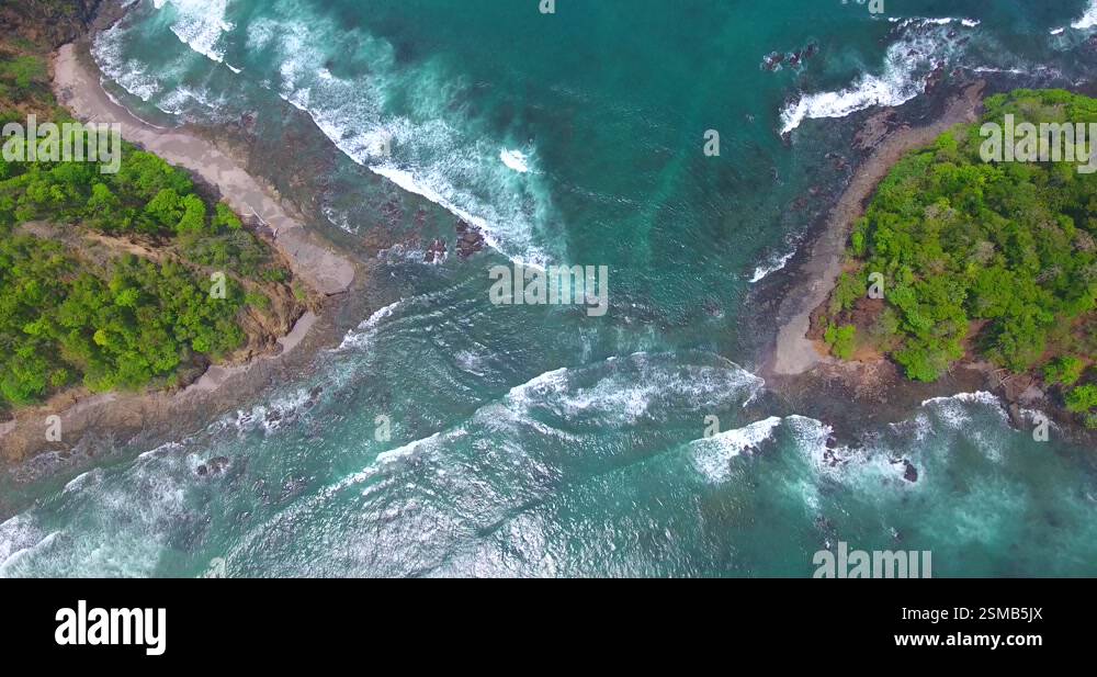 Flying straight up from the blue ocean water flowing between islands ...