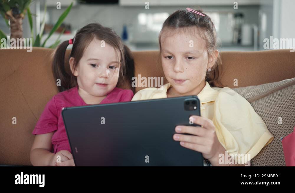 Two little sisters use digital tablet computer Stock Video Footage - Alamy