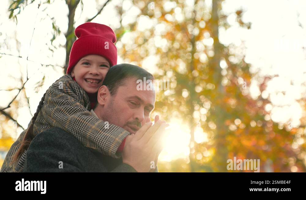 Caring father blows on small hands of smiling daughter warming with ...