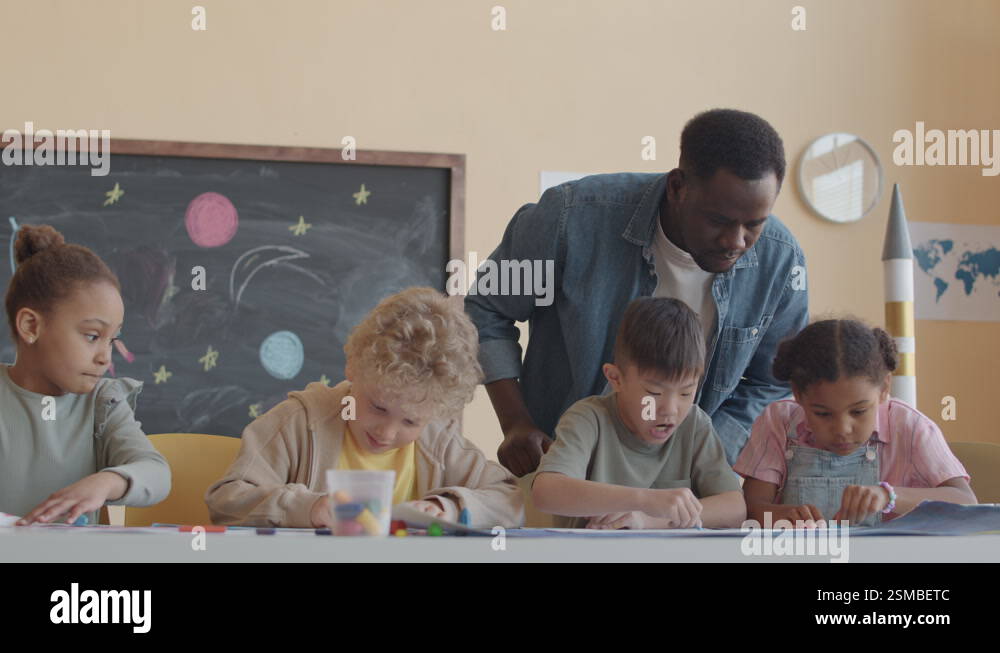 Primary School Teacher Helping Kids with Drawing during Art Class Stock ...