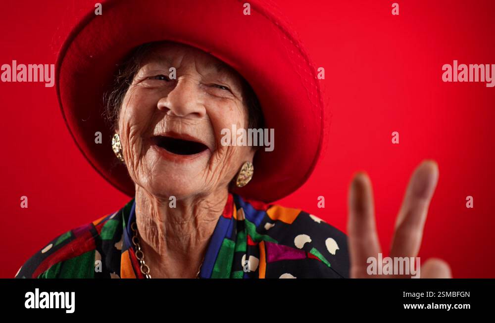 Playful, elderly mature woman, 80s, giving peace sign gesture with no ...