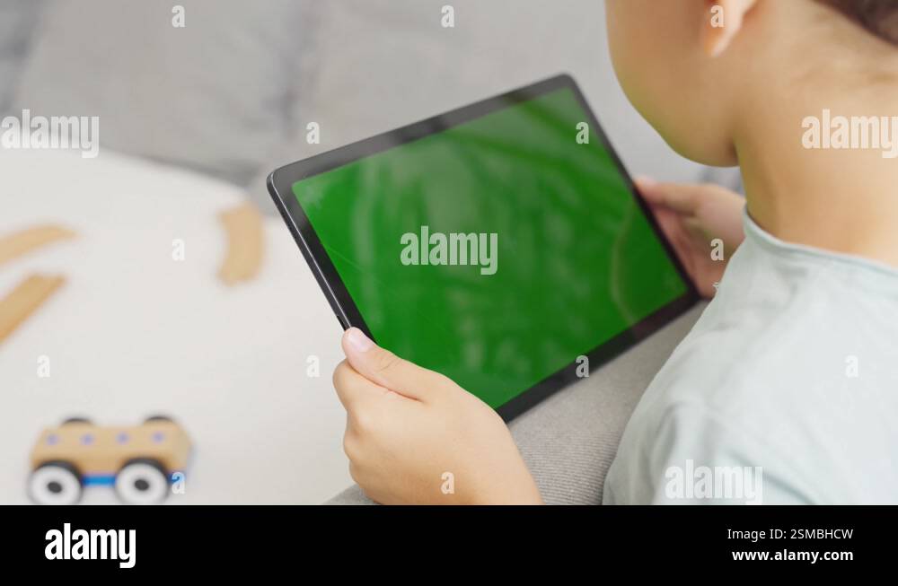 Close up kids hands holding, tapping on a tablet with green screen ...