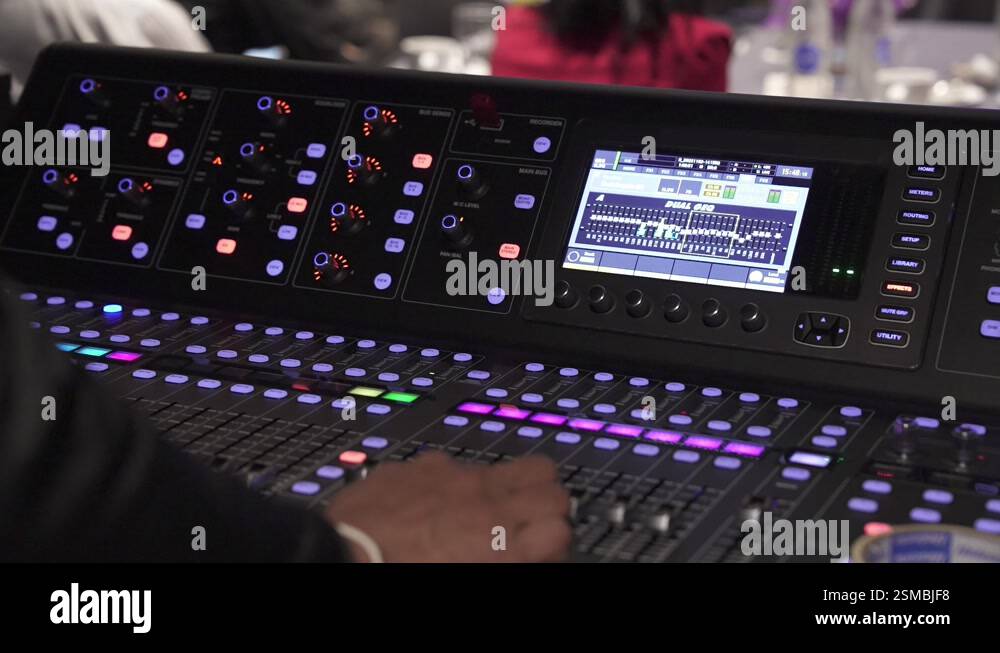 real sound maestro navigates the mixing board at a live event checking ...