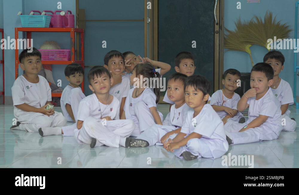 Thai school kids, donned in crisp white uniforms, joyfully wave to the Stock Video Footage - Alamy