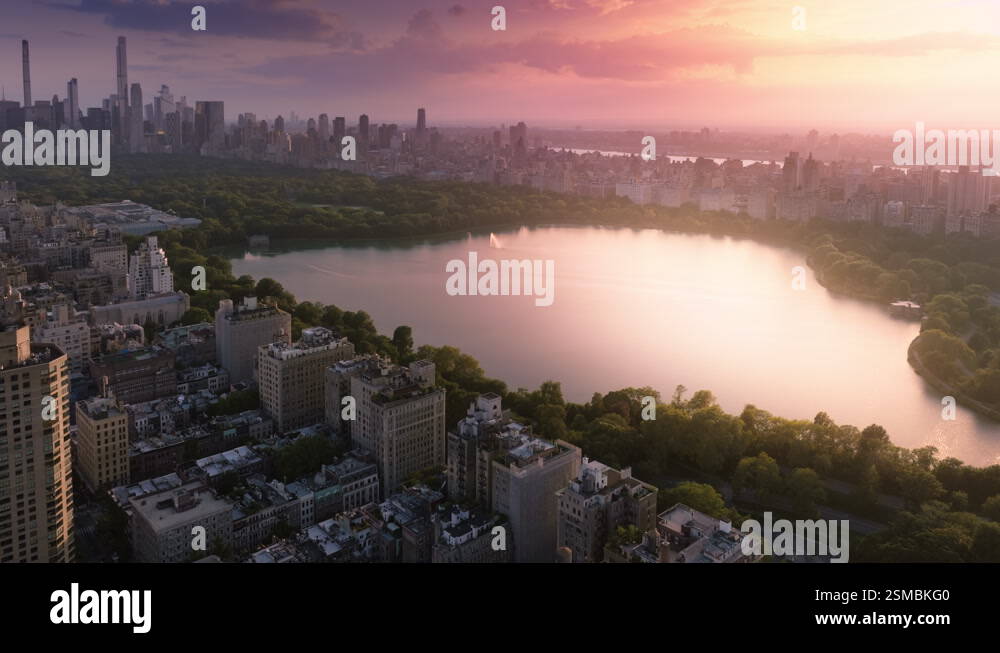 Epic pink sunset above green Central park, Scenic lake reflecting sky ...