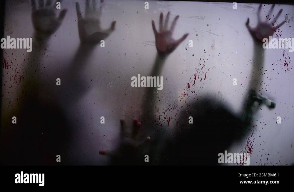 Blurry zombie hands claw at blood-splattered window. Eerie presence of ...