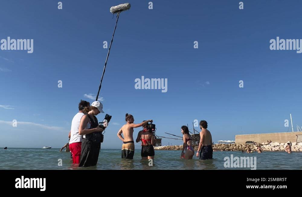 Film troupe bathing in sea water filming scenes of boys and girls ...