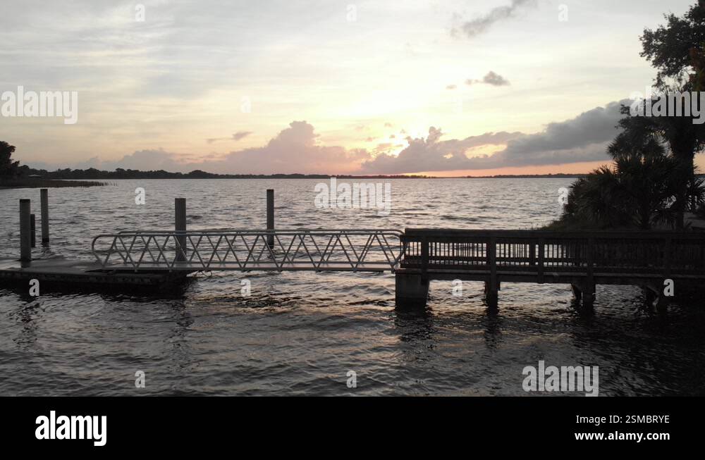 Slow push in Aerial drone wide shot of marina boat dock with lighthouse ...
