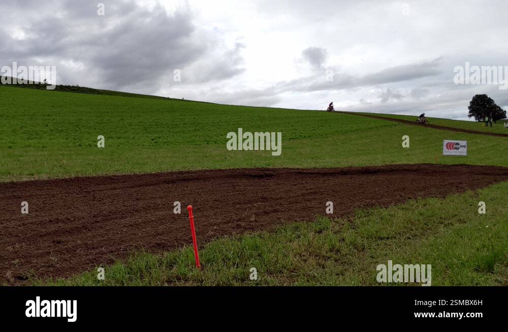 Motocross riders driving around a turn on dirt track with motorcycles ...