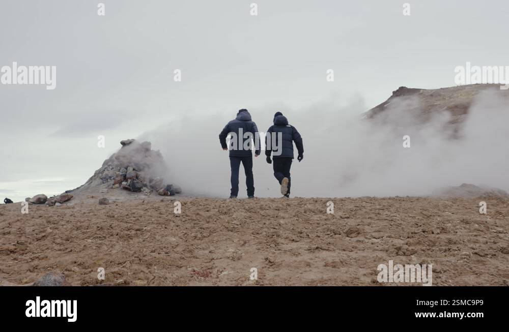 People walk through dense vapor cloud from steam vent and disappear ...