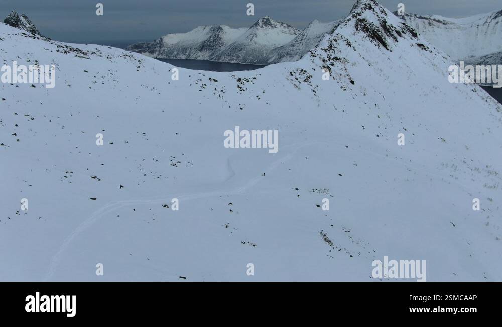 Drone view in Tromso area in winter flying over a snowy mountain in ...