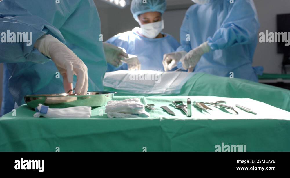 Diverse surgeons operating on patient using surgical instruments in ...