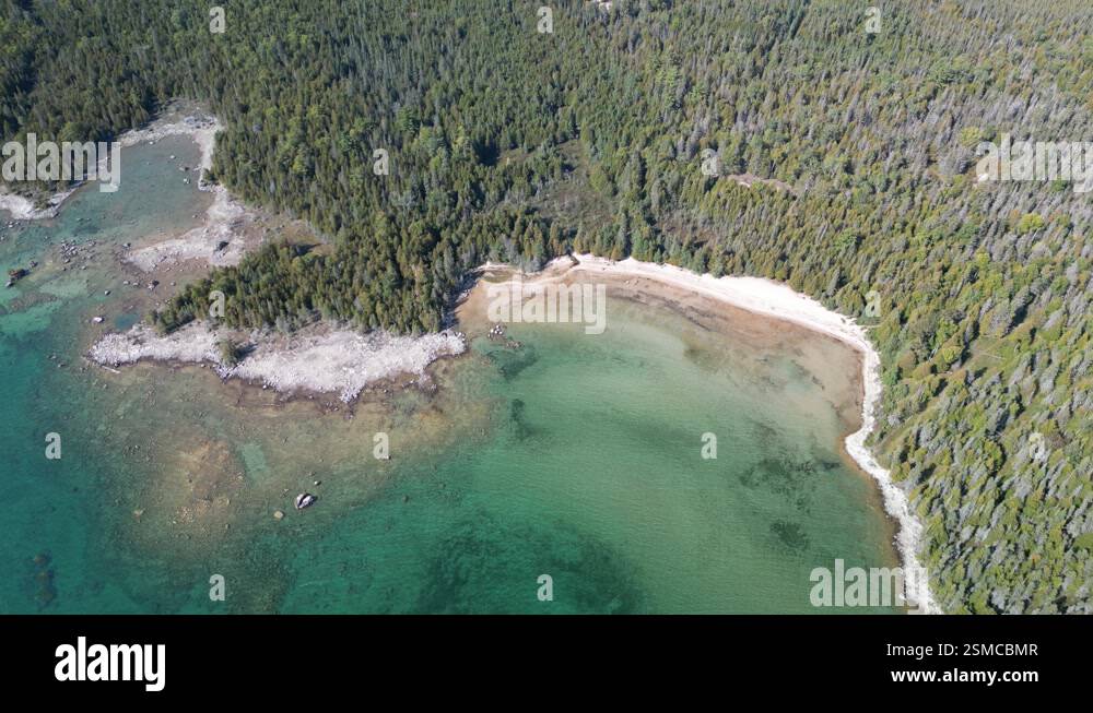 aerial high altitude of forested rocky lake huron coastline, michigan ...