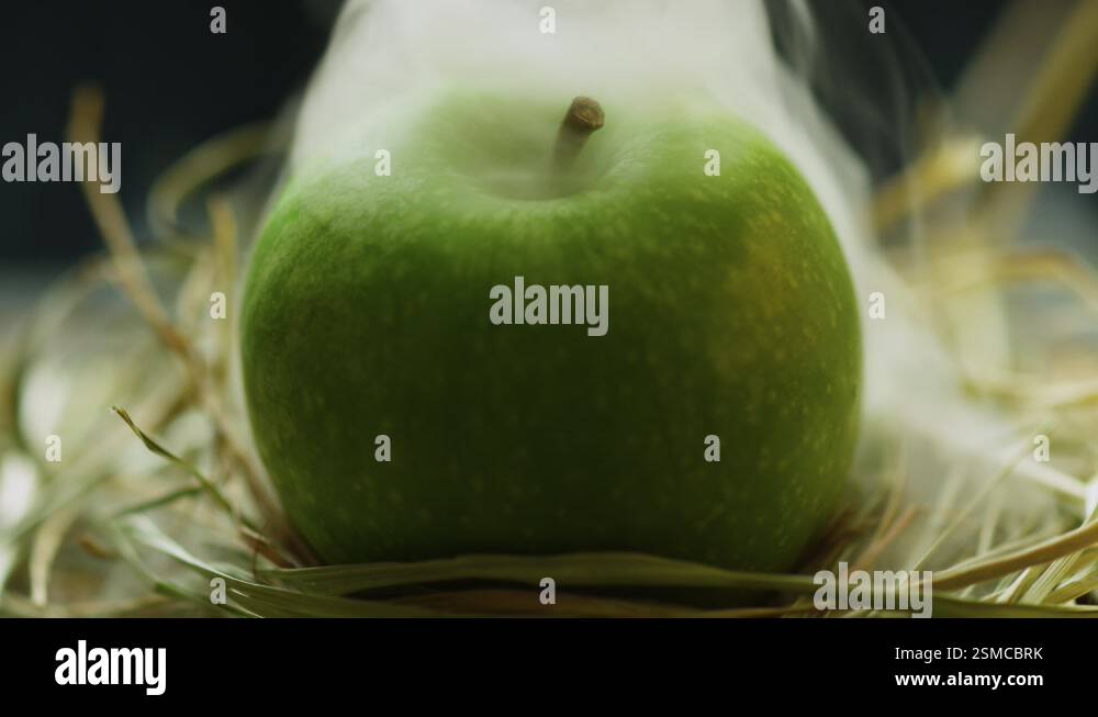An Apple With Mist Over It Sits In Straw As It Rotates In A Studio ...