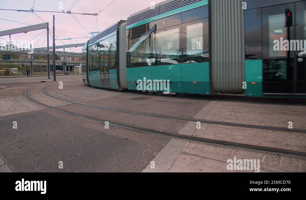 Shiny new public transit street tram turns corner in Helsinki Finland ...
