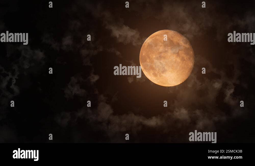 Full bright moon with craters behind moving clouds and small streams of ...