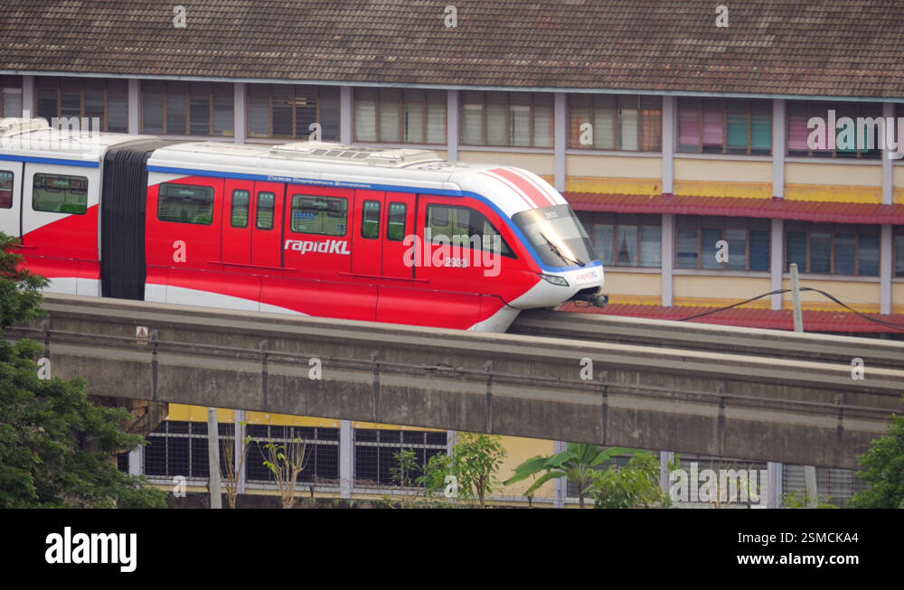 Tracking telephoto shot of monorail car moving against building, slow ...