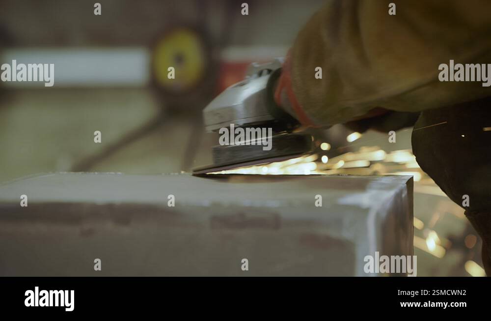 Grinding metal with an electric grinder in the workshop, and a shower ...