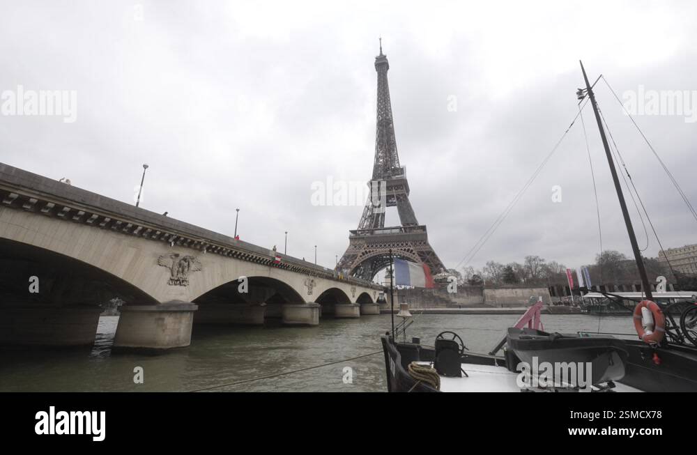 Eiffel Tower view from the riverbanks, a French flag on a floating ...