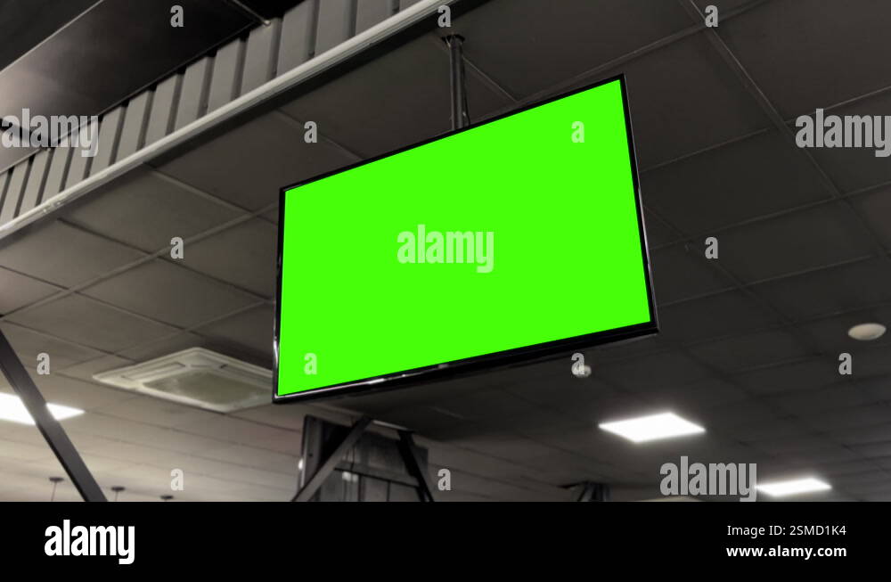 Chromakey green screen on a flat-screen TV, ceiling-mounted in a gym ...