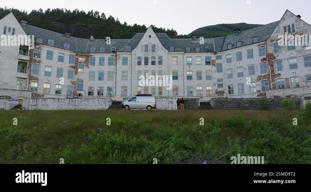 Low aerial of tourists and van in front of mysterious Lyster Sanatorium ...
